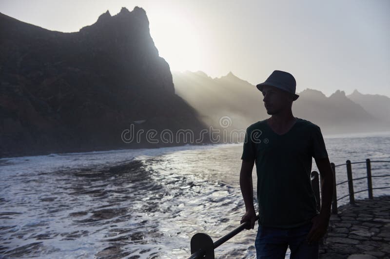 Man Standing on a Sandy Beach Next To the Vast Ocean, the Waves Gently ...