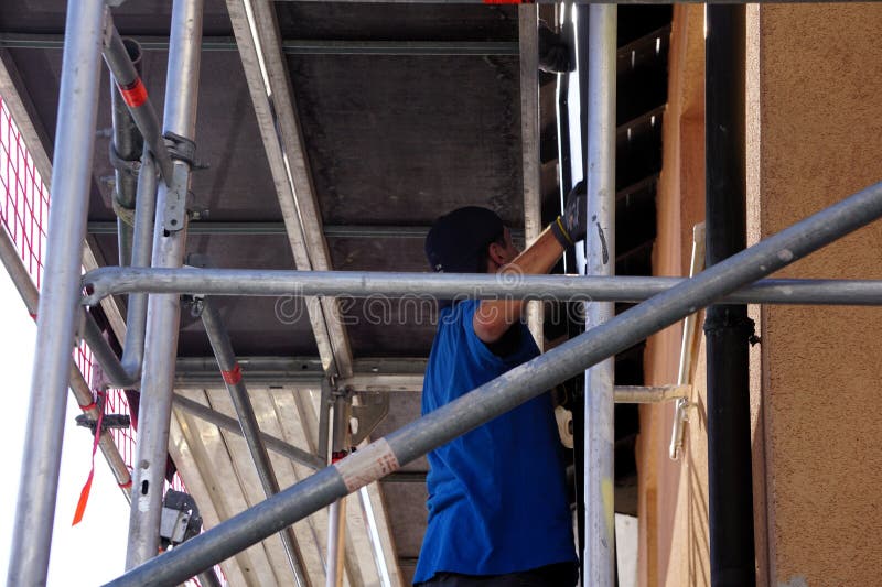 A Man is Standing on a Scaffolding Platform Working Stock Image - Image ...