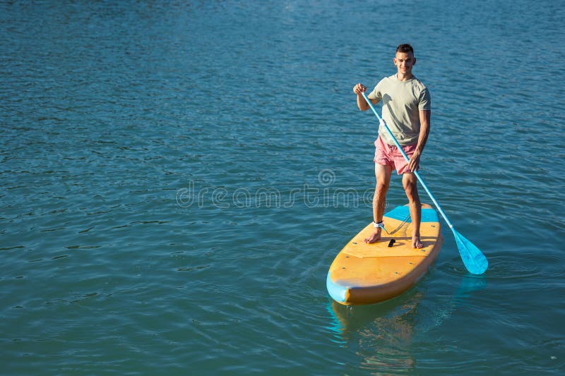 Man Standing on the Supboard in Ocean. Stock Photo - Image of ...