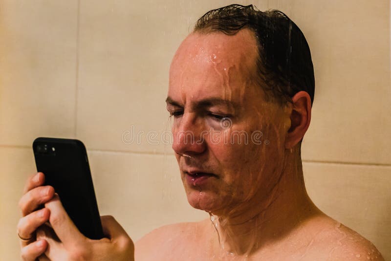 Man Standing Under a Shower with a Mobile Phone in His Hand. Stock ...