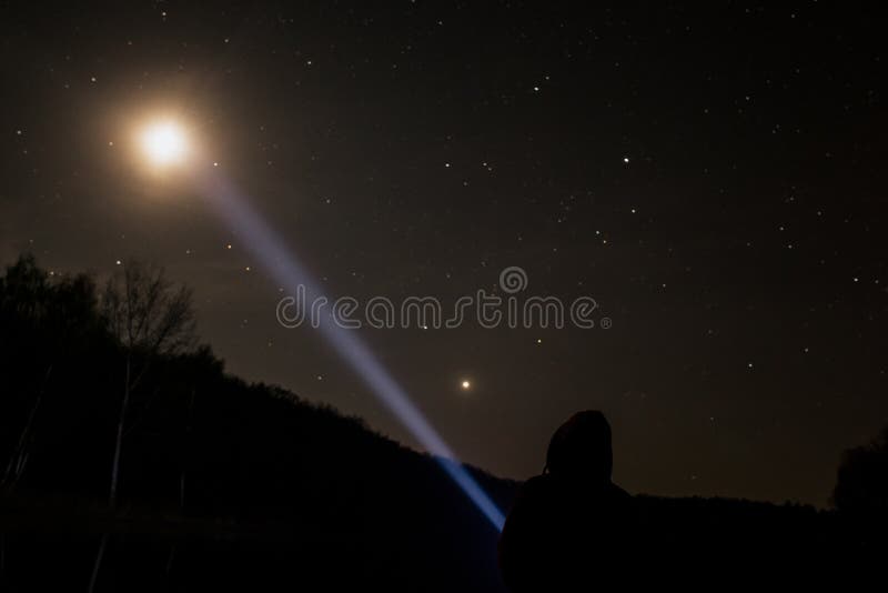 Man Standing Under the Starry Sky and Shining a Flashlight on the Moon ...