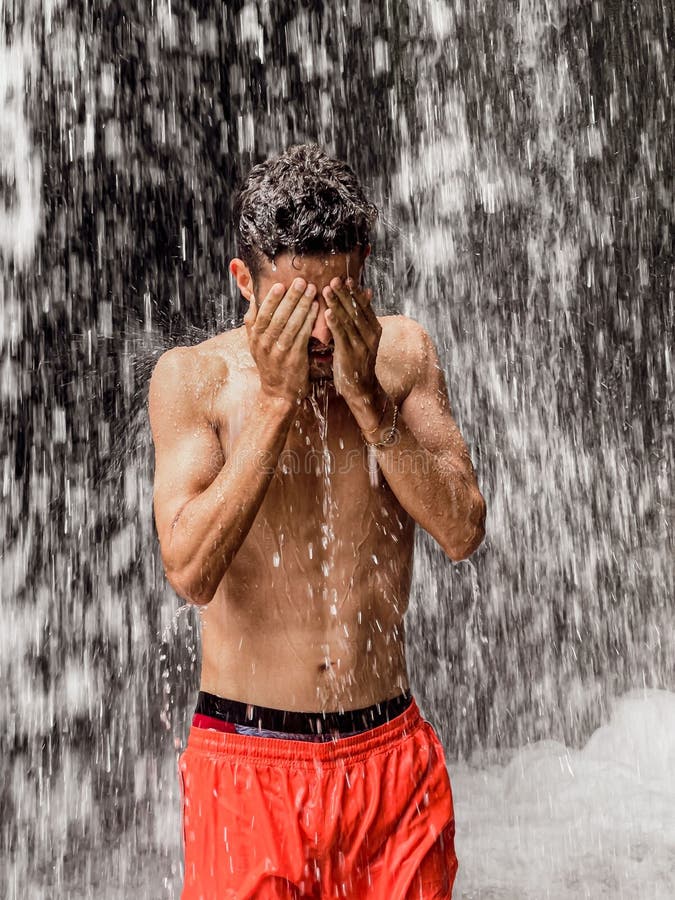 Man Standing Under a Waterfall Stock Image - Image of flowing, cascade ...