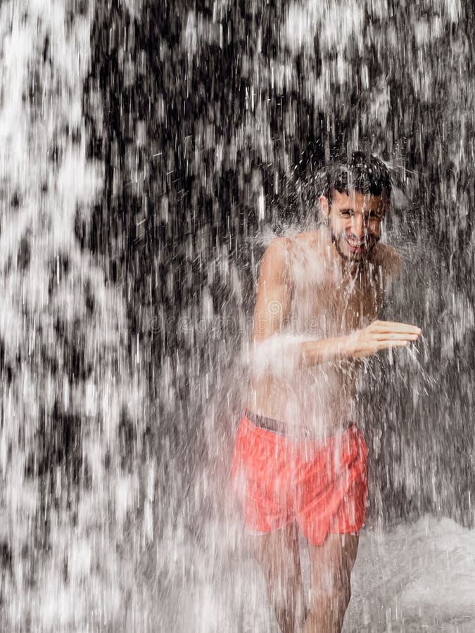 Man Standing Under a Waterfall Stock Image - Image of person, adventure ...