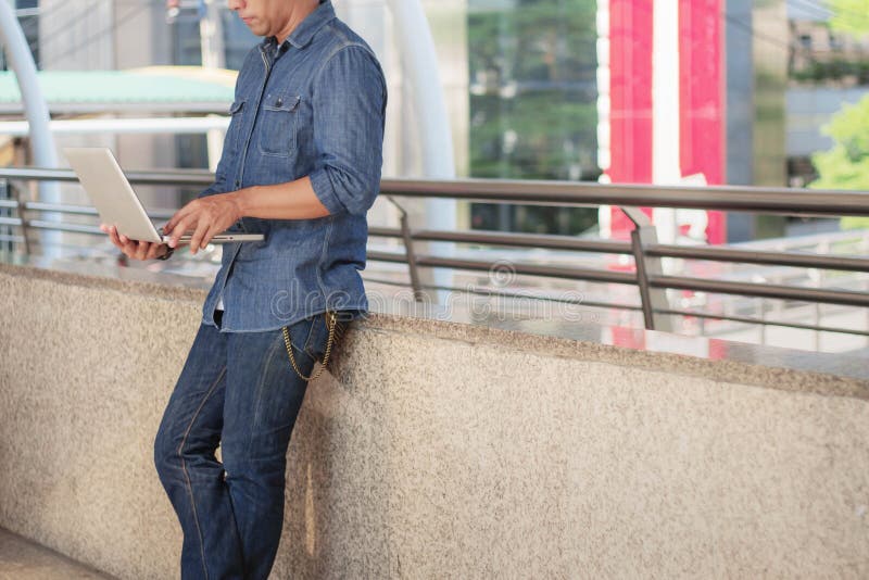 Man is Standing Using Computer. Stock Photo - Image of jeans, bangkok ...