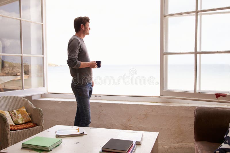 Man Standing at Window and Looking at Beautiful Beach View Stock Photo ...