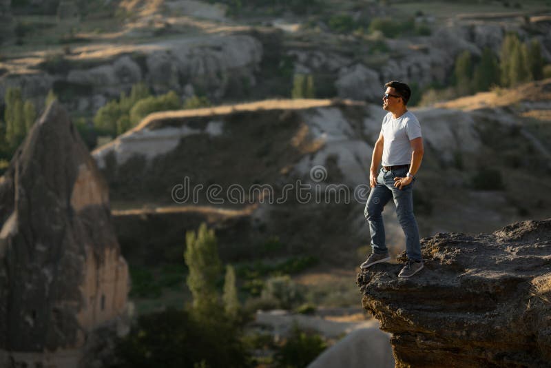Man Stands on Cliff and Looks into the Distance. Stock Photo - Image of ... Man Stands on Cliff and Looks into the Distance. Stock Photo - Image of ...