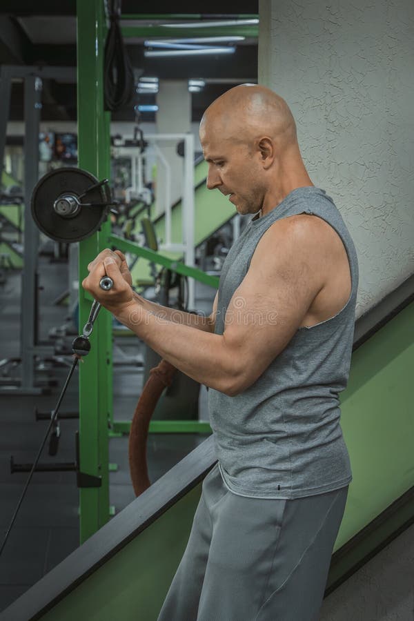 Man in a Simulator Performs an Exercise for Pumping Biceps in the Gym ...