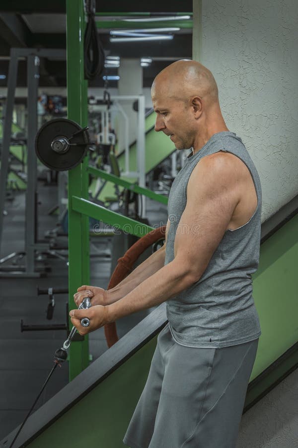 Man in a Simulator Performs an Exercise for Pumping Biceps in the Gym ...