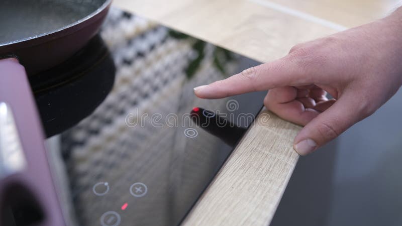 A Man Stands in Front of an Induction Hob with a Red Button on it ...