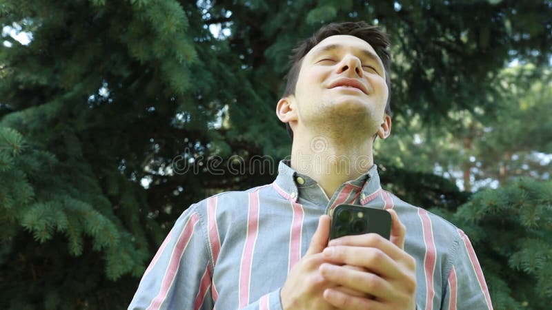Man Standing in Front of Tree Using Cell Phone Stock Video - Video of ...