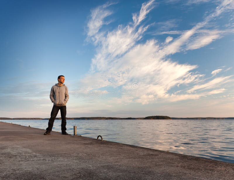 A Man Stands on the Pier Starring at the Sea Stock Photo - Image of ...