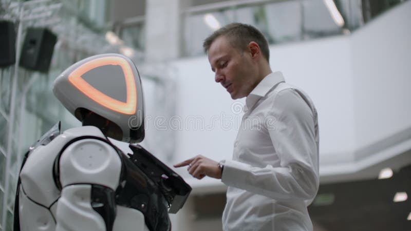 A Man Stands with a Robot Bot and Asks Him Questions and Asks for Help ...