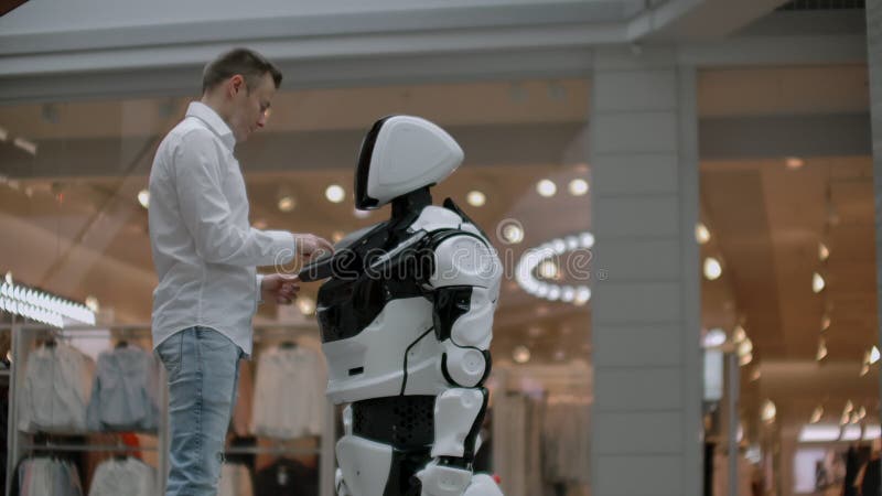 A Man Stands with a Robot Bot and Asks Him Questions and Asks for Help ...