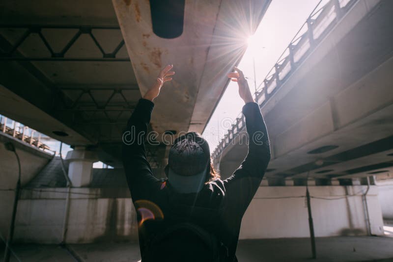 A Man Stands Under a Flyover with His Hands Raised To the Light Stock ...