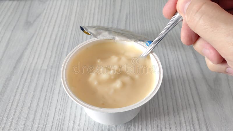 Man is Stirring Pudding with Rice in a Plastic Jar with a Spoon ...