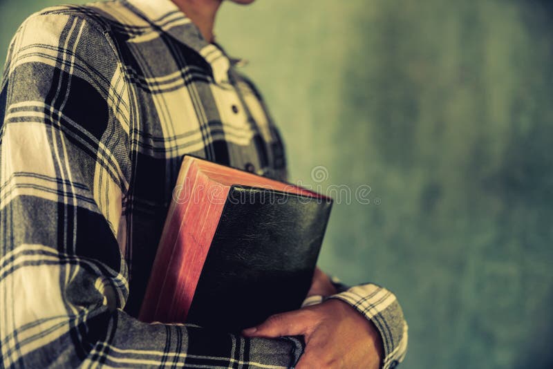 A Young Man Holding a Bible in His Hands Stock Photo - Image of ...
