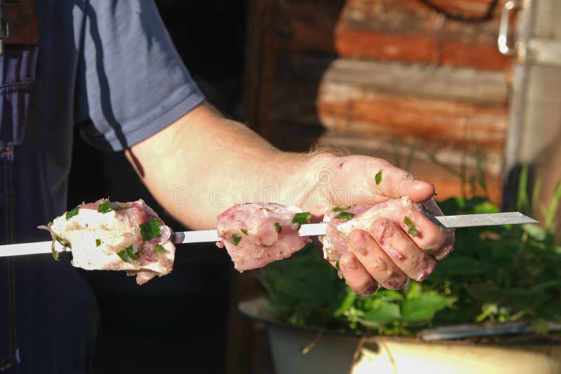 A Man Strands Pickled Meat on a Skewer. a Man Puts Meat on a Skewer ...