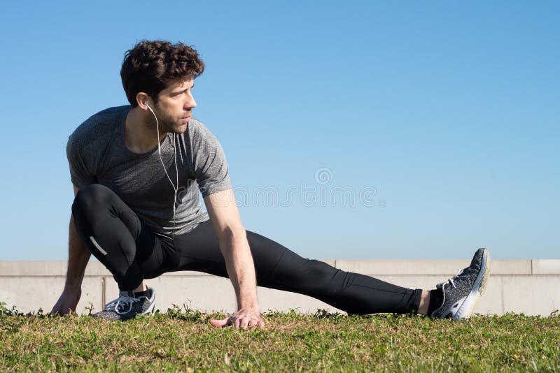 Man Stretches Leg in the Ground Stock Image - Image of turf, earpieces ...