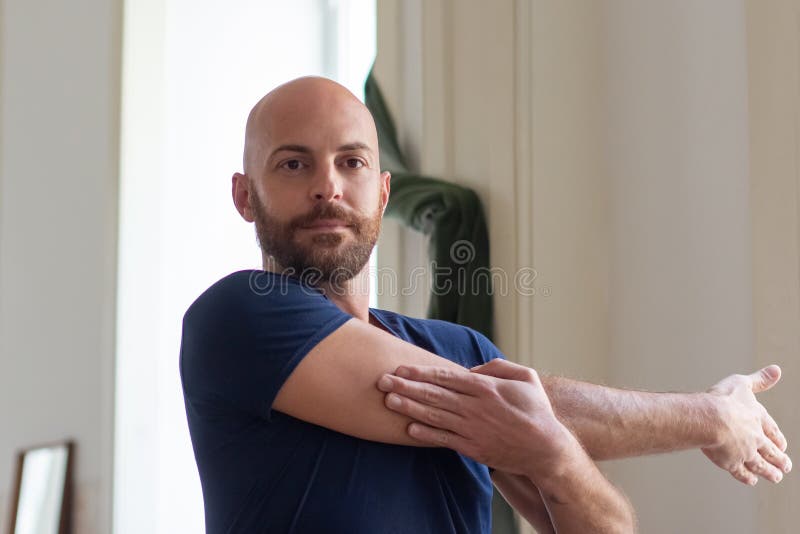 Man Stretching Arm at Home and Looking at Camera Stock Photo - Image of ...