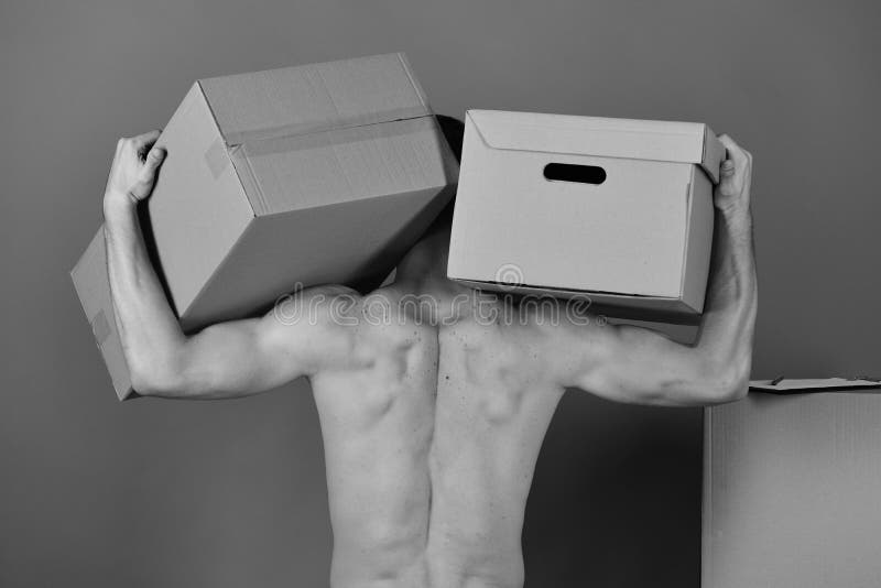 Man With Strong Arms Among Cardboard Boxes Delivery And Moving In