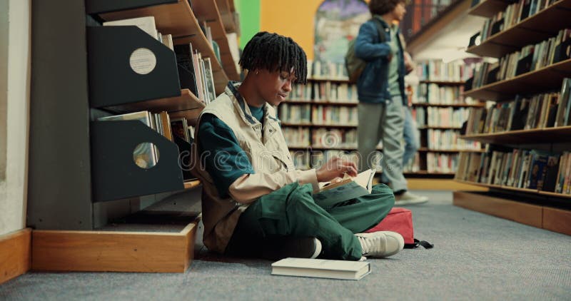 Man, Student and Reading with Book in Library on Floor for Education ...