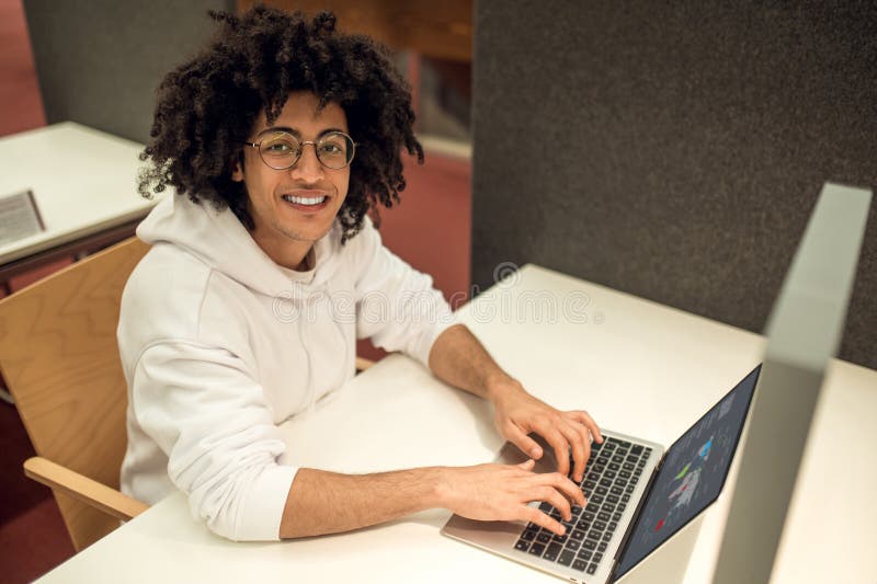 Man Studying with Computer Preparing for Exams in High School Library ...