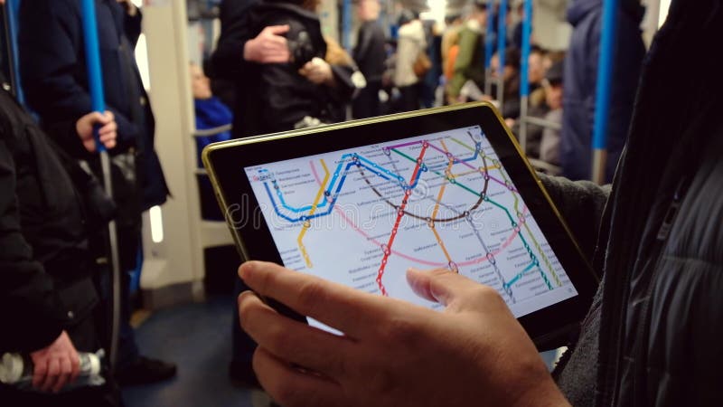 Man Studying a Subway Map on a Tablet Computer Riding at Underground ...
