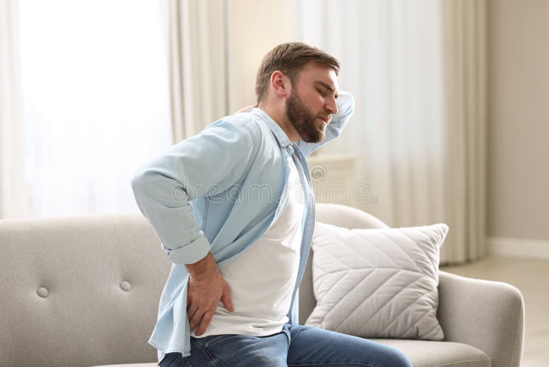 Man Suffering from Back Pain at Home. Bad Posture Problem Stock Photo ...