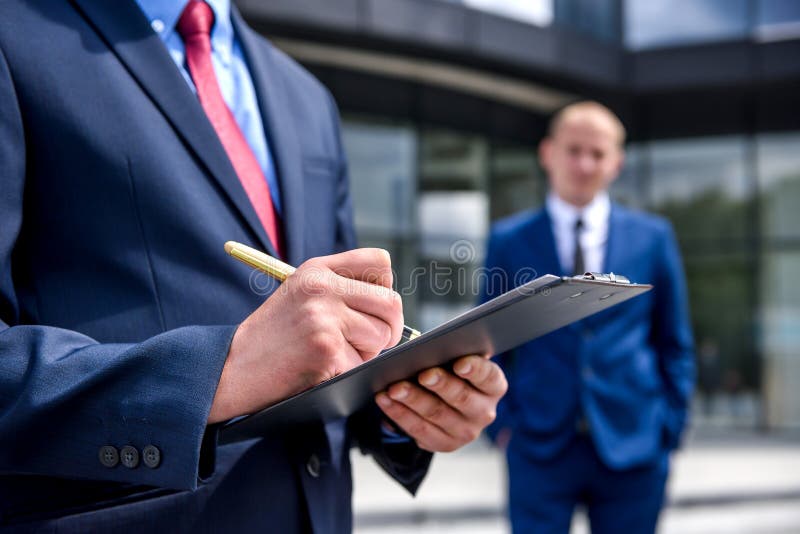 Man in Suit with Clipboard Standing Outdoors Stock Photo - Image of ...