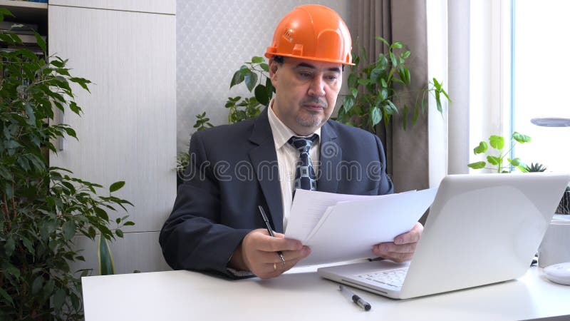A Man in Suit and Hard Hat Working at His Desk Stock Photo - Image of ...