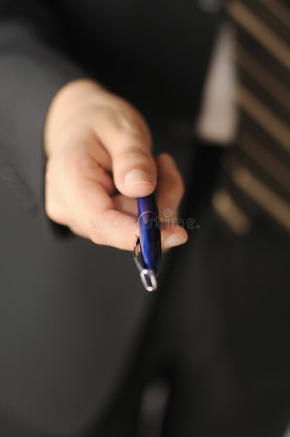 A Man in a Suit Holds Out a Pen Stock Photo - Image of human, agreement ...