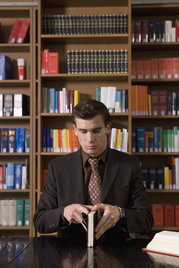 Man in Suit Opening Book at Library Desk Stock Image - Image of library ...