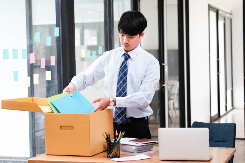 A Man in a Suit is Opening a Cardboard Box on a Desk Stock Photo ...