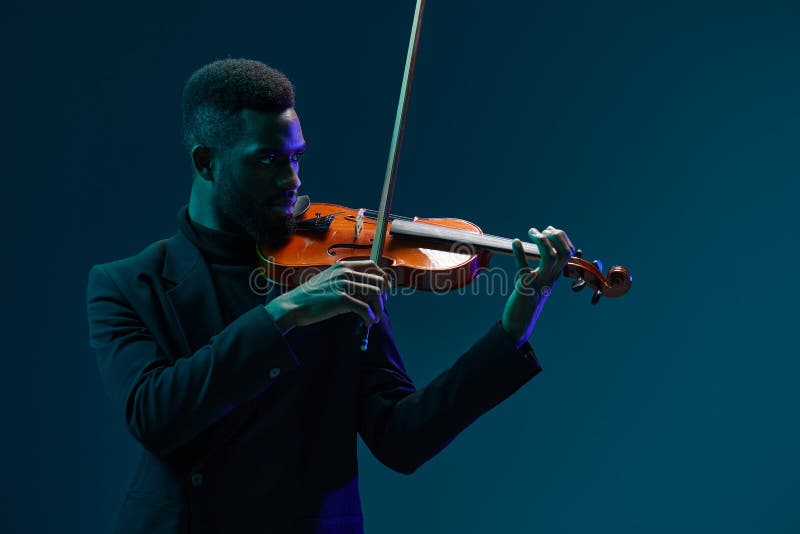Man in Suit Playing Violin in Dramatic Lighting Against Dark Background ...