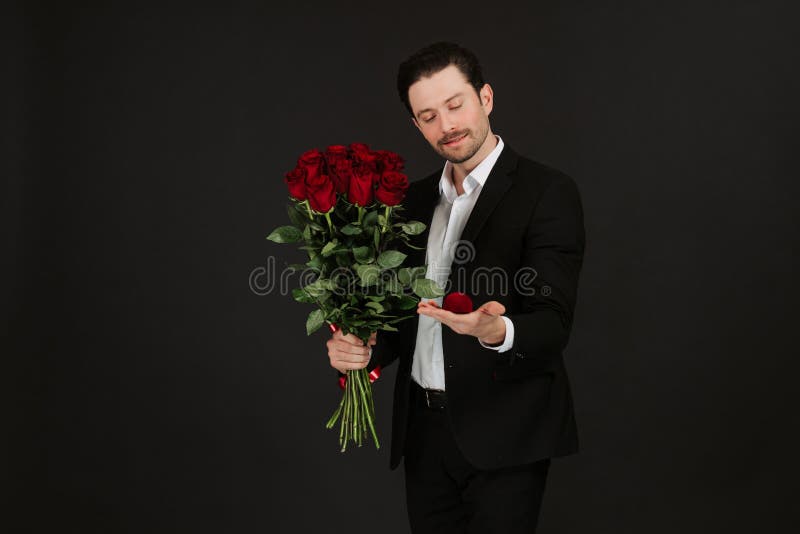 Woman is Standing with Roses in Hands Man is Making Proposal with Ring ...