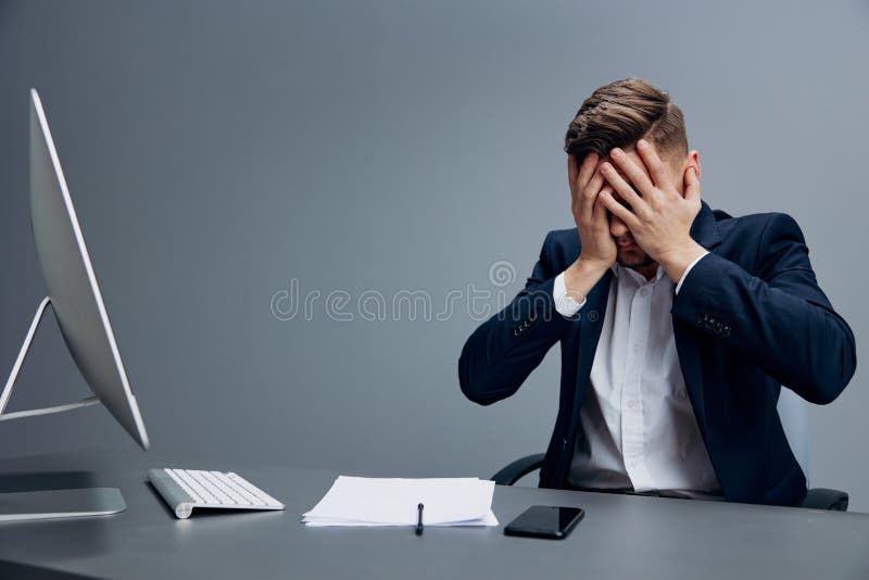 A Man in a Suit Problems at Work Sitting at a Desk in Front of a ...