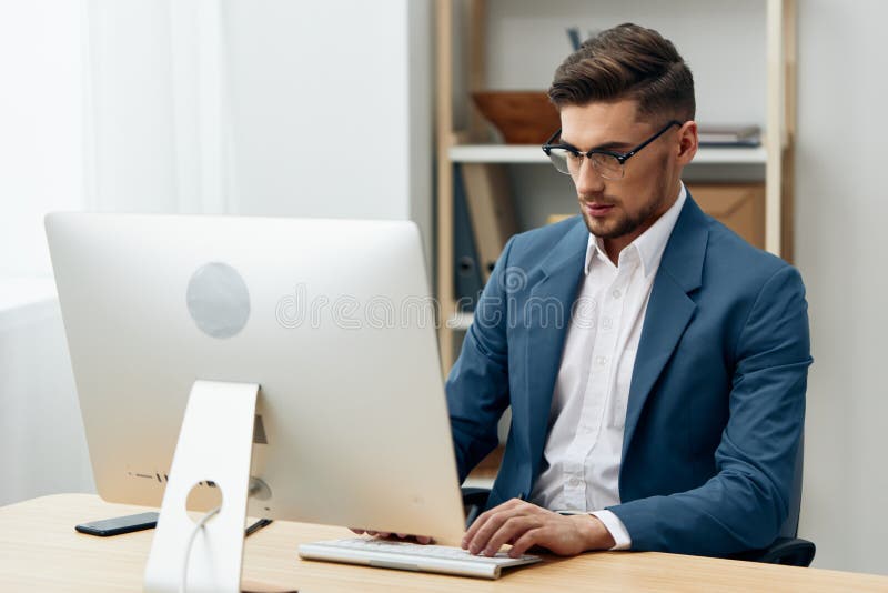 A Man in a Suit Sitting at the Computer Work Boss Technologies Stock ...