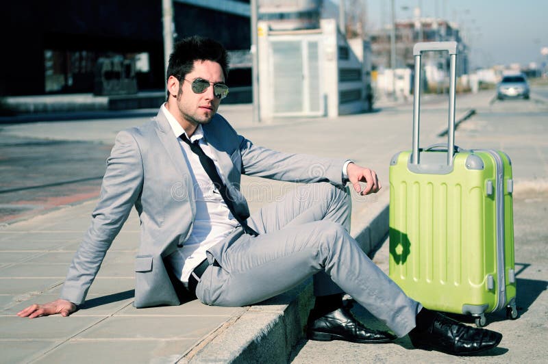 Man with Suitcase Sitting in the Street Stock Image - Image of grey ...