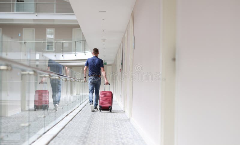 Man with Suitcase Walking Down in Hotel Corridor Back View Stock Image ...