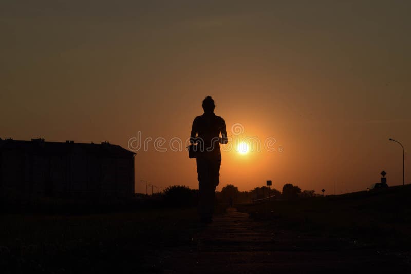 The man at sunset stock photo. Image of slow, walks, road - 66393880