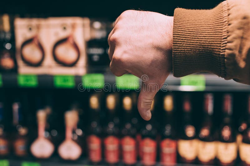 A Man in a Supermarket Shows a Finger at the Bottom Against a ...