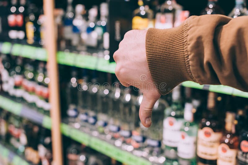 A Man in a Supermarket Shows a Finger at the Bottom Against a ...