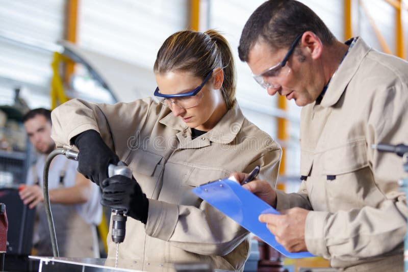 Man Supervising Woman Using Bench Drill Stock Photo - Image of year ...