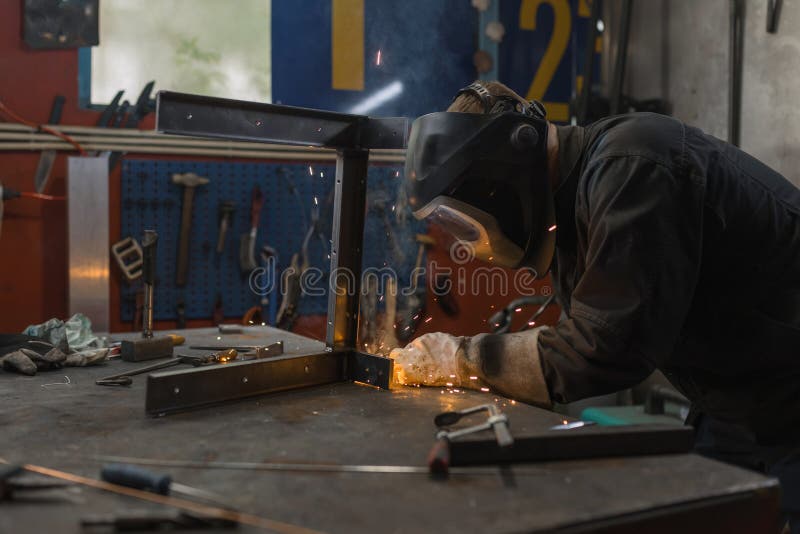 Man Surrounded by Sparks in an Engineering Workshop Focused on His ...