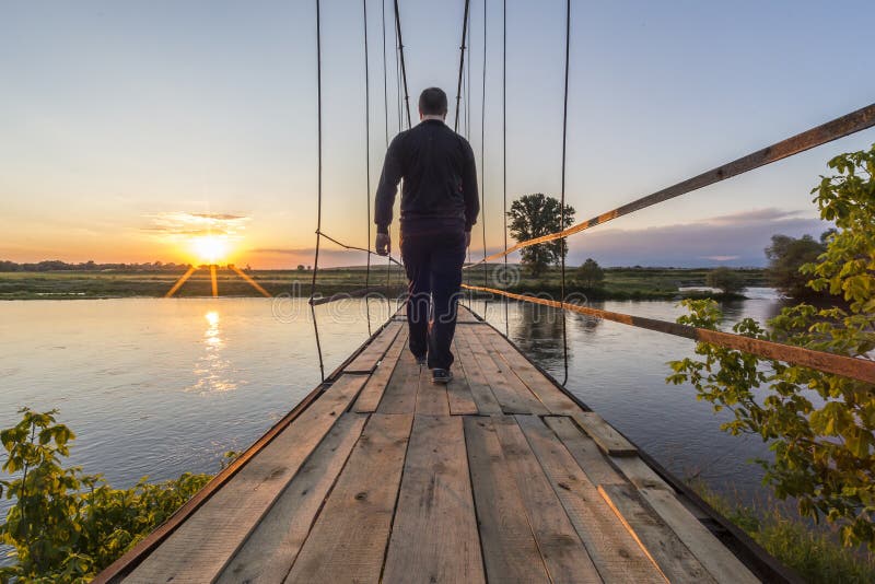 Man on a suspension bridge stock photo. Image of scenic - 134360378