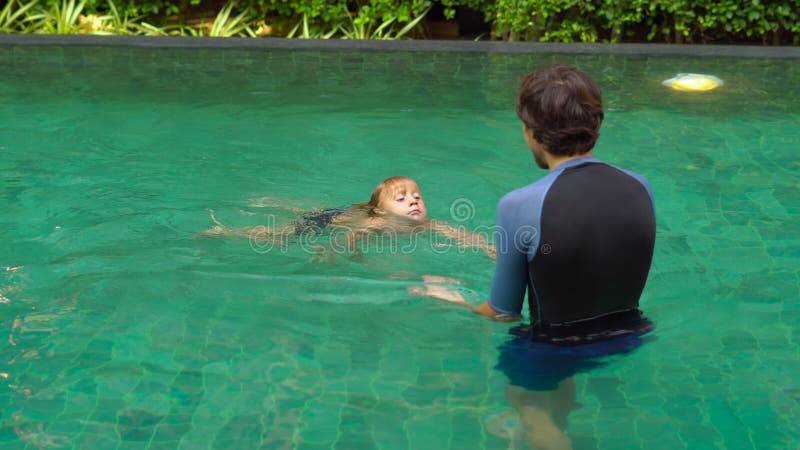 Man Swimming Instructor Teaches Little Boy Swimming in the Pool Stock ...