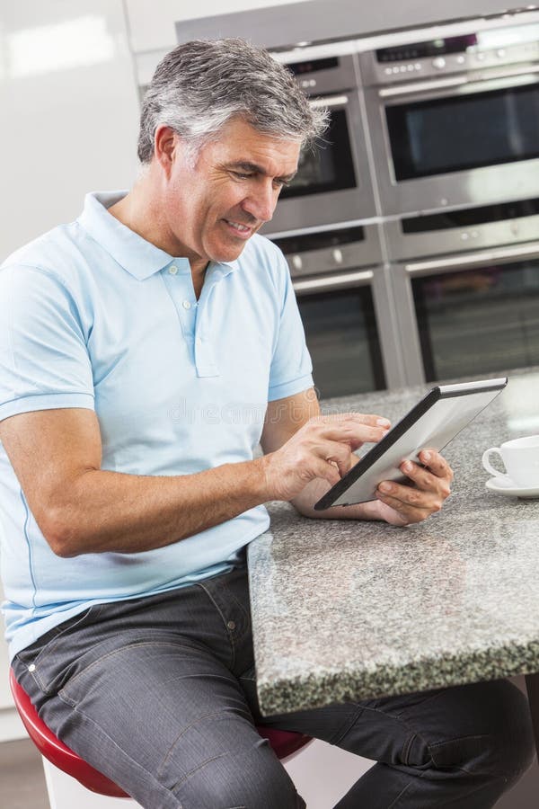 Man on Tablet Computer in Kitchen Drinking Coffee Stock Photo - Image ...