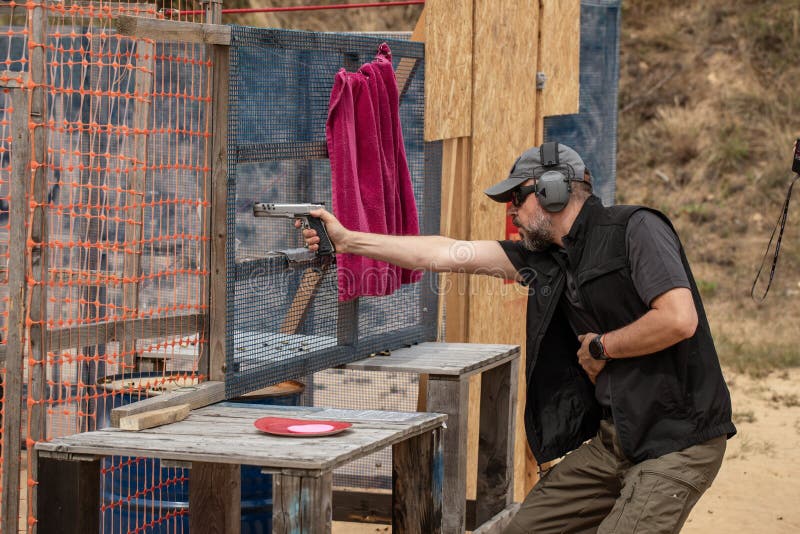 Man in Tactical Clothes Shooting from a Pistol, Reloading the Gun and ...