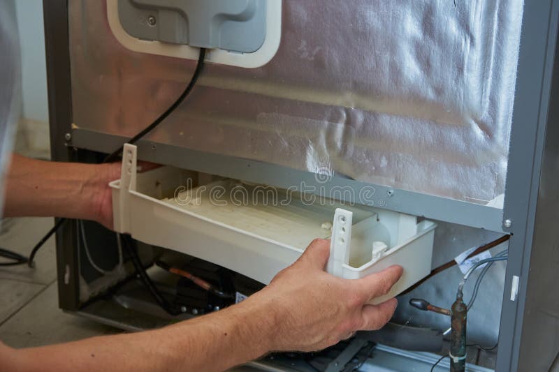 Man Takes Compressor Tray with Water from Refrigerator, Defrosting ...