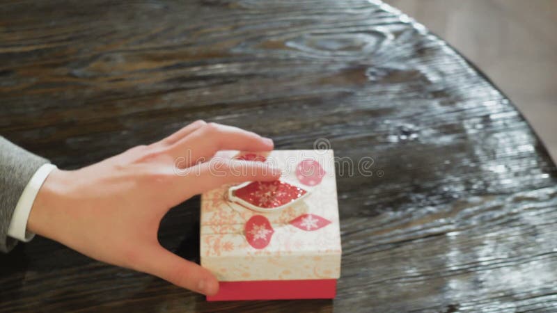 A Man Takes a Gift Box from Under the Table and Puts it on the Table in ...